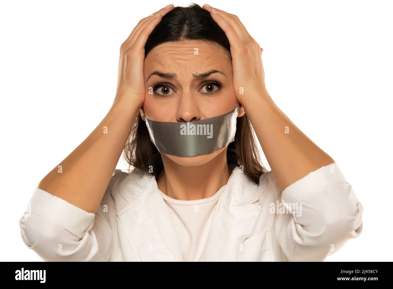 Unhappy young woman with adhesive tape over her mouth on a white ...