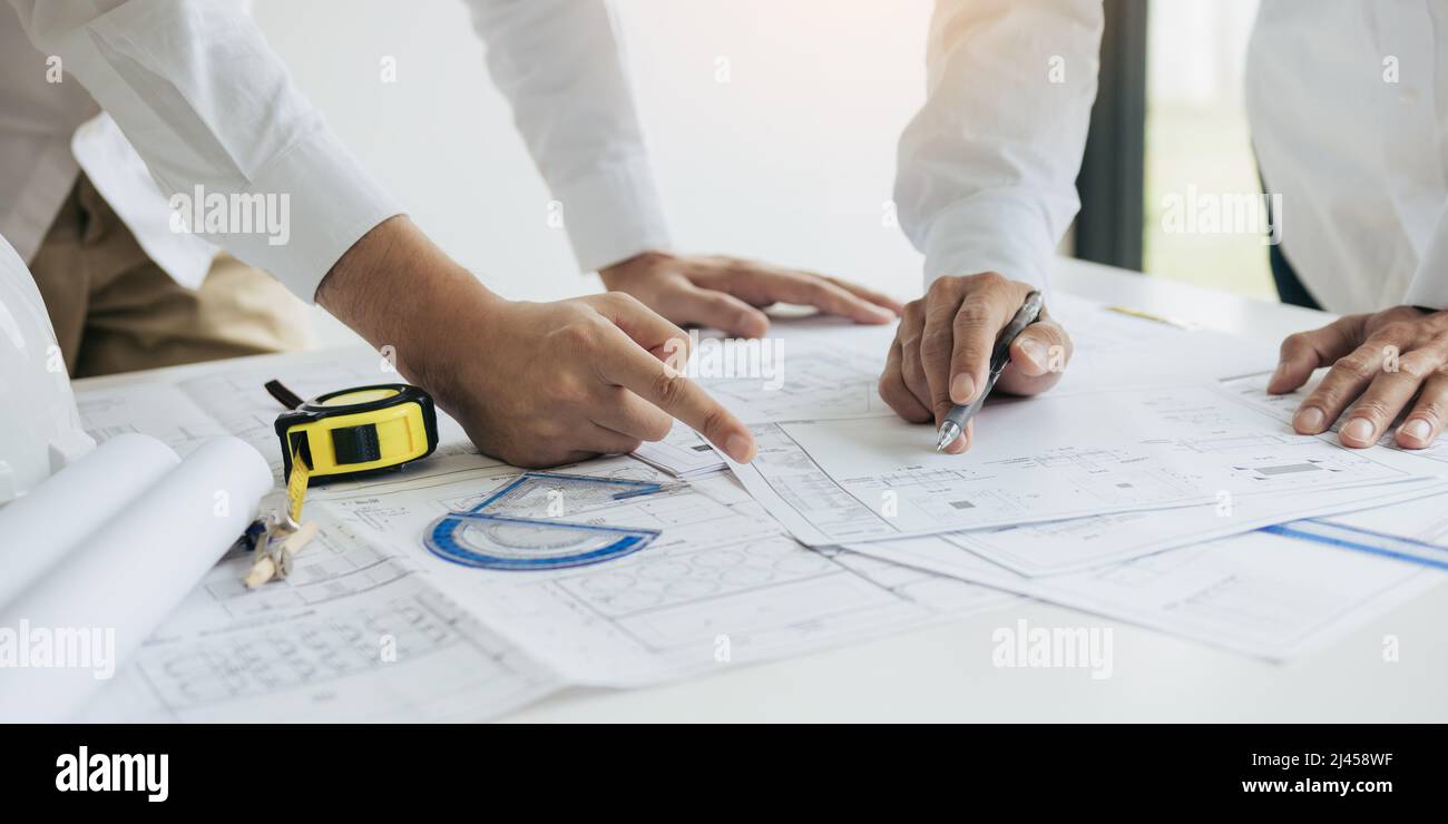 Two partnership architects or engineering working with blueprints and ...
