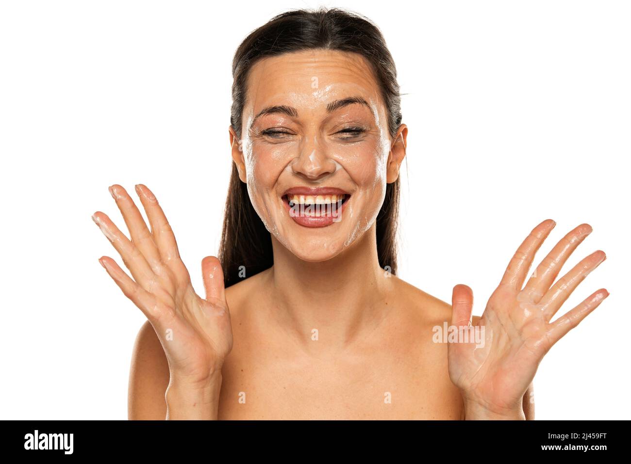 Portrait of a smiling woman with smeared makeup removing lotion on her ...