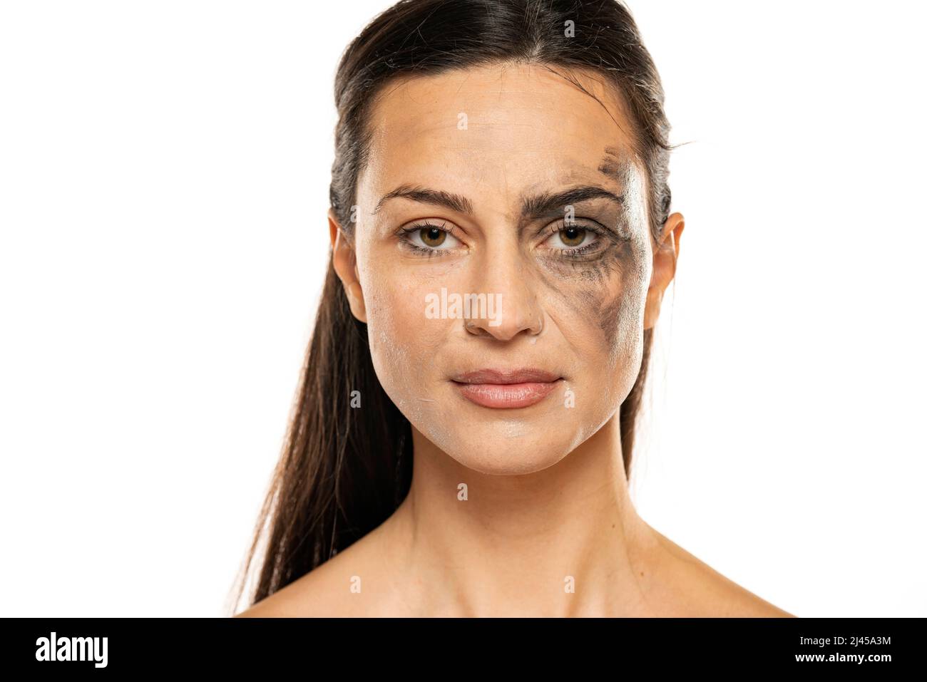 a young woman posing with half face dirty and half cleansed of makeup ...