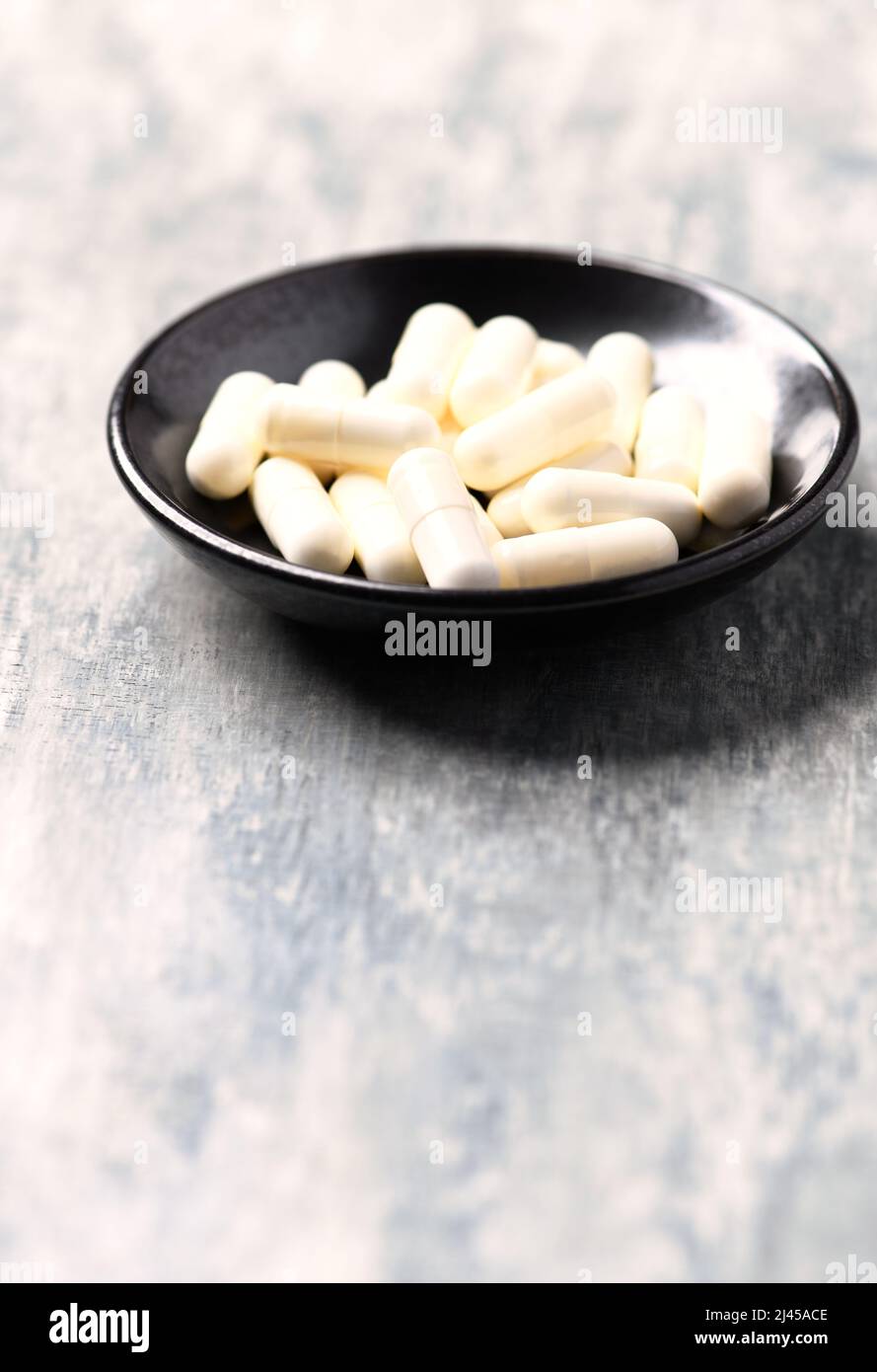 Beta-alanine capsules. Bodybuilding food supplements on wooden ...