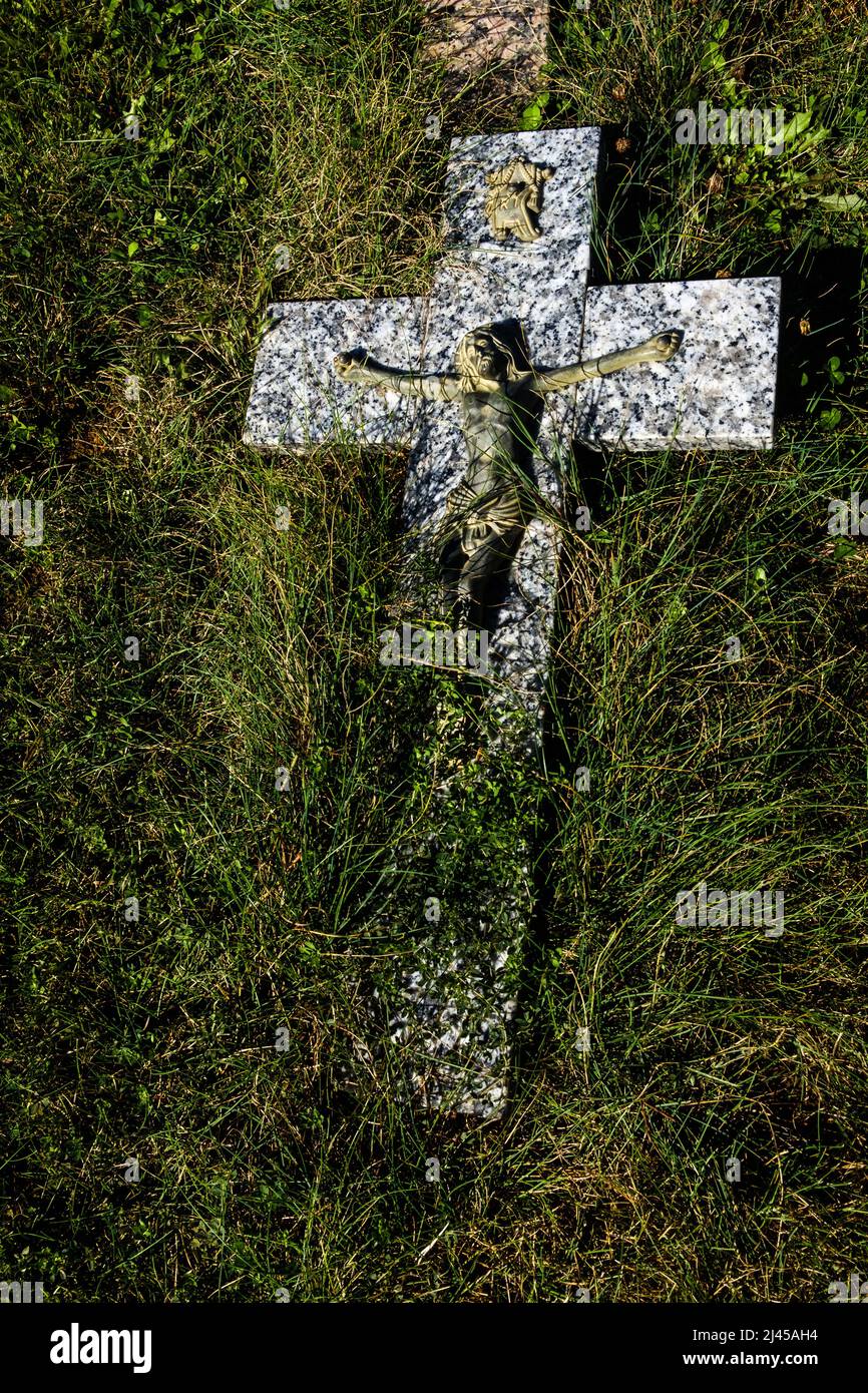 Jesus Christ on the cross covered in grass on an abandoned tomb in the ...