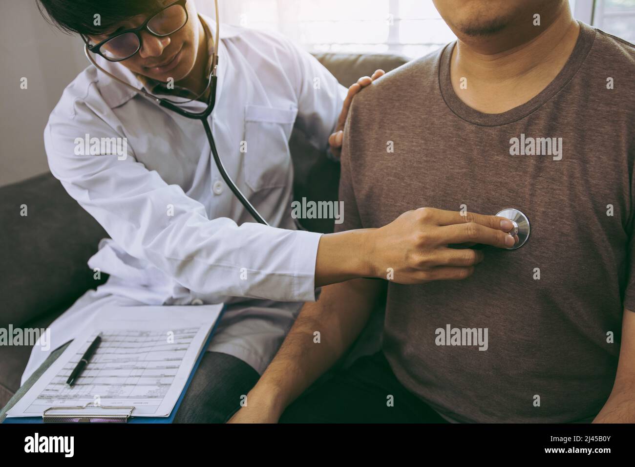 Asian doctor is using a stethoscope listen to the heartbeat of the ...