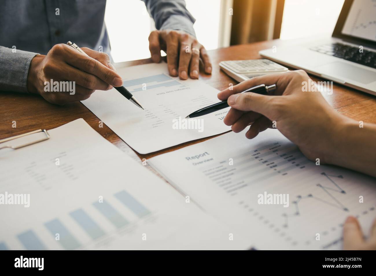 Business partnership pointing to the graph of the company financial ...