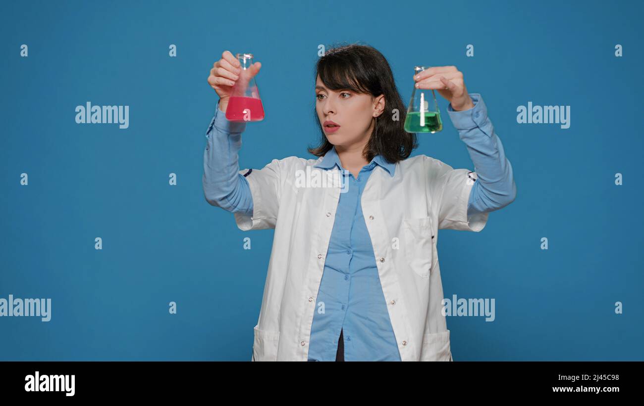Scientific specialist analyzing liquid formula in glass beaker, using ...