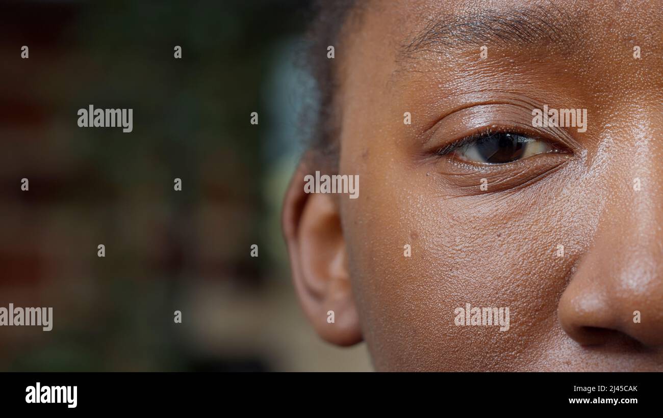 Macro shot of young adult smiling and looking at camera, showing one ...