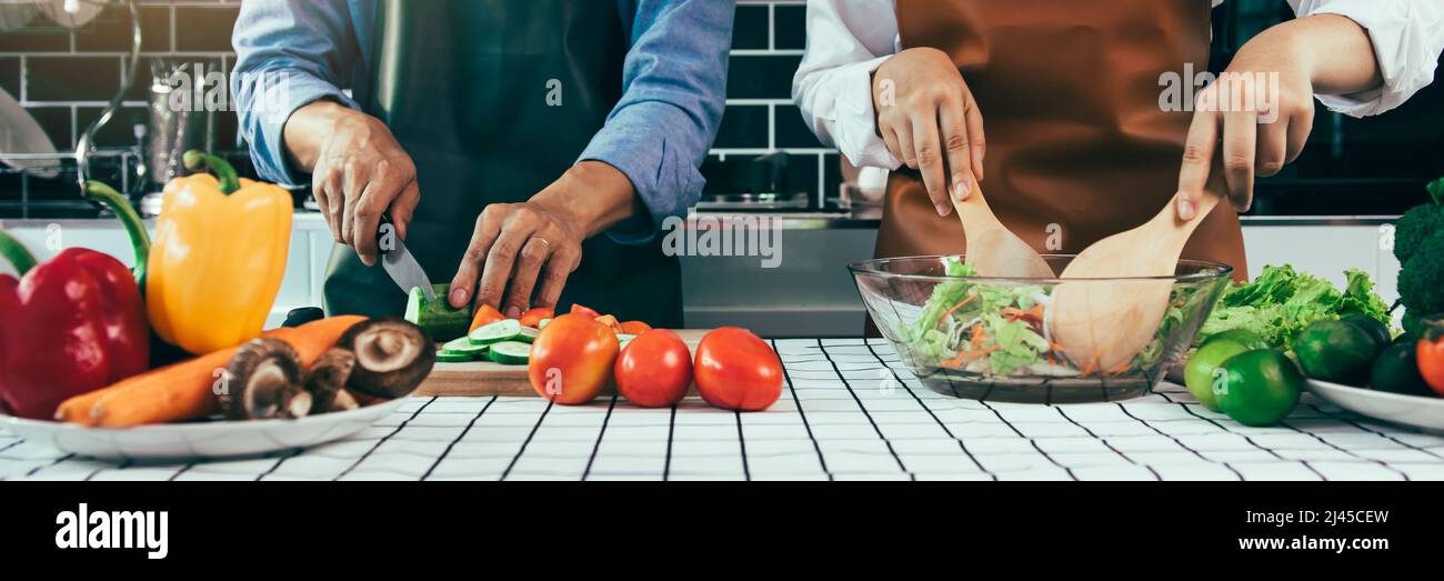 Two young asian couples are helping each other and enjoying cooking in ...