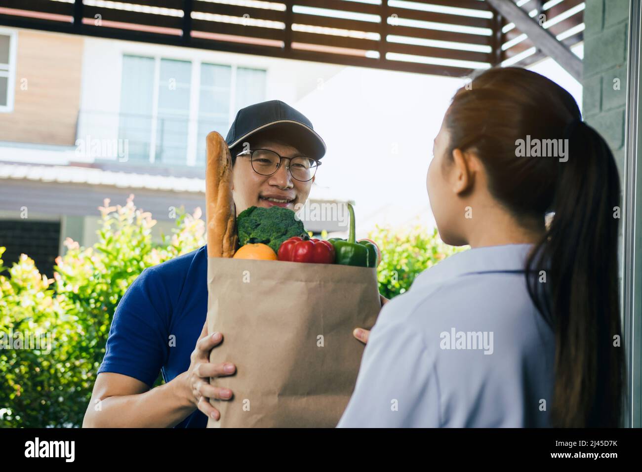 Supermarket food delivery staff deliver bags to female customers in ...