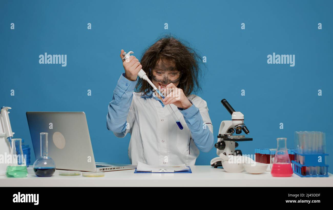 Insane goofy scientist using micro pipette and test tube in front of ...