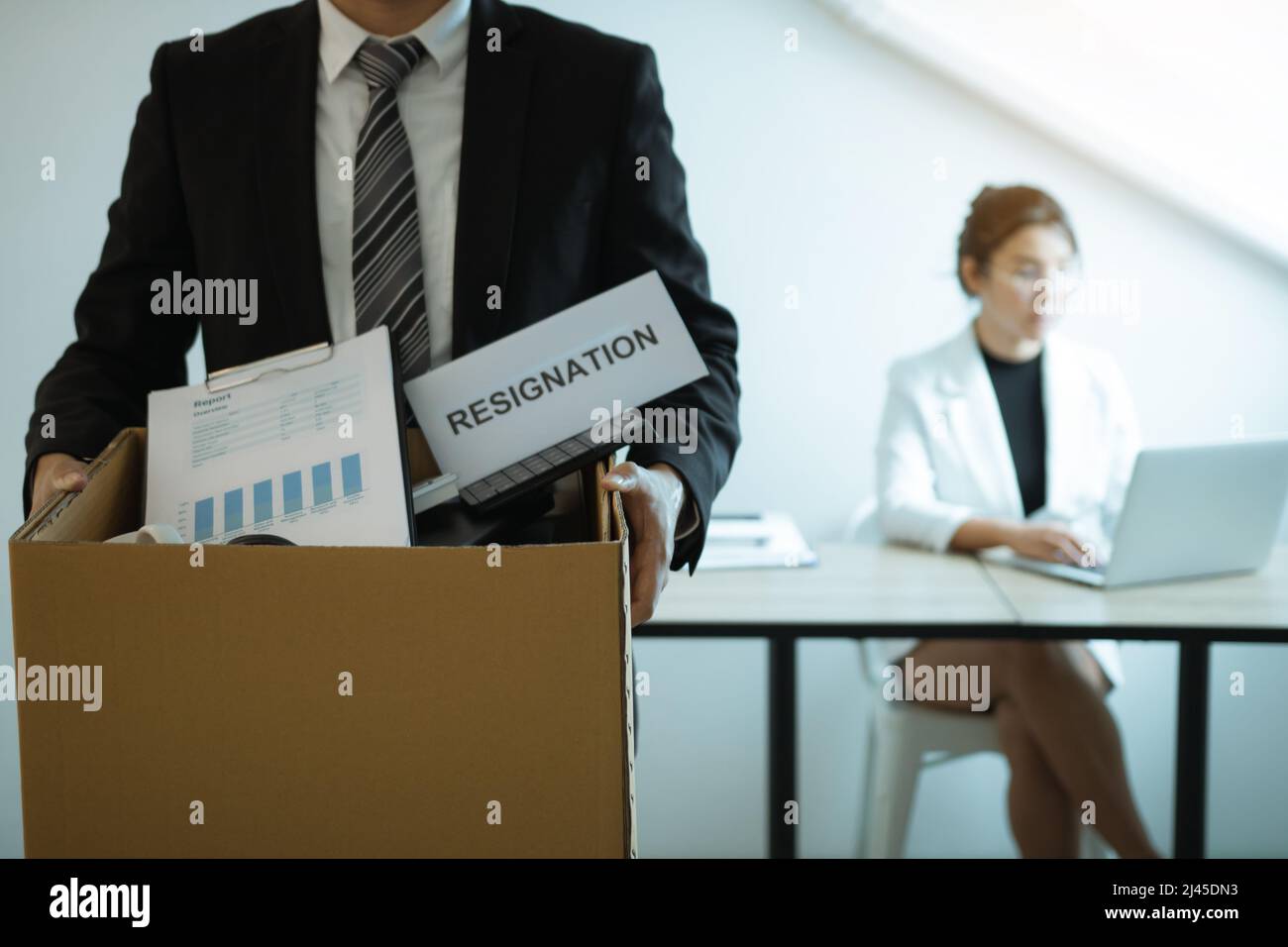 Front view with the male employee standing holding office supplies in ...