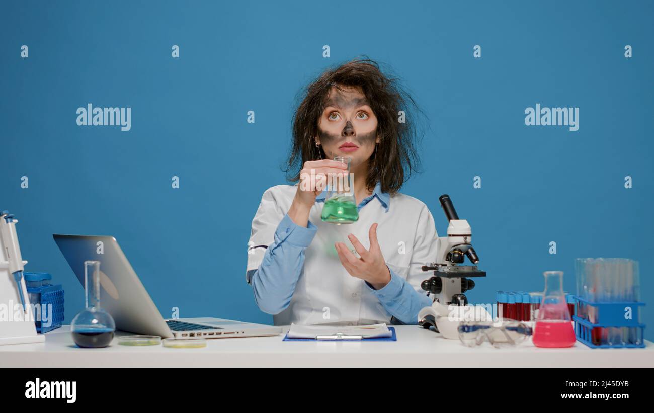 Crazy amusing chemist analyzing lab beaker and acting insane, being ...
