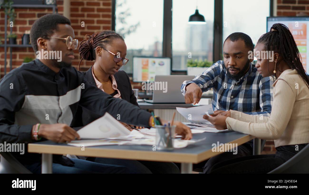 Team of african american businesspeople analyzing charts documents ...