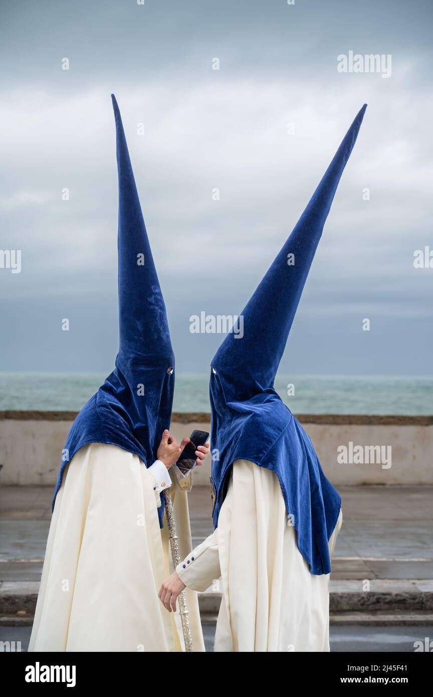 Cadiz, Spain. 11th Apr, 2022. Two people consult a mobile phone as they ...