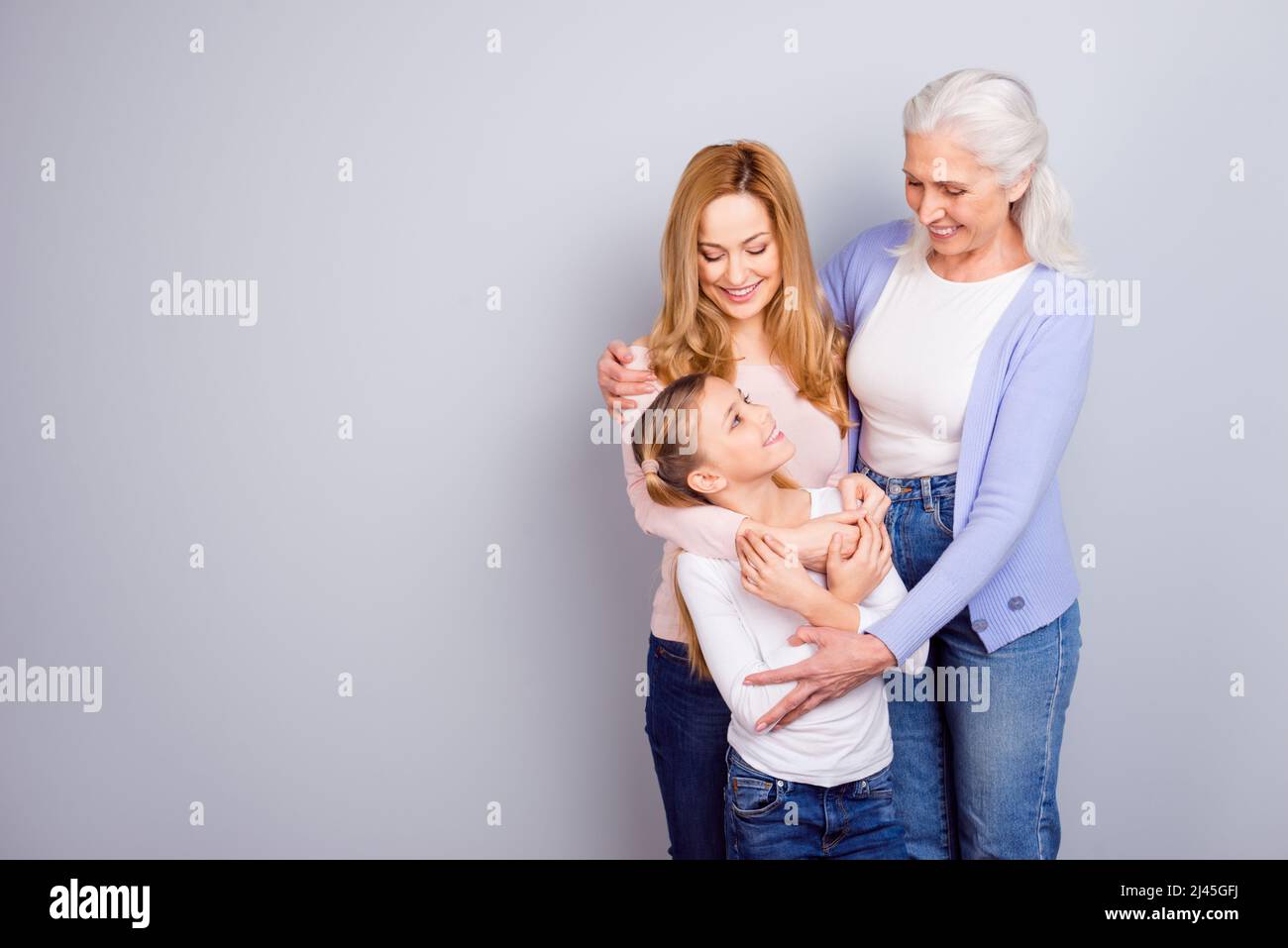Portrait of three peaceful positive people cuddle look each other ...