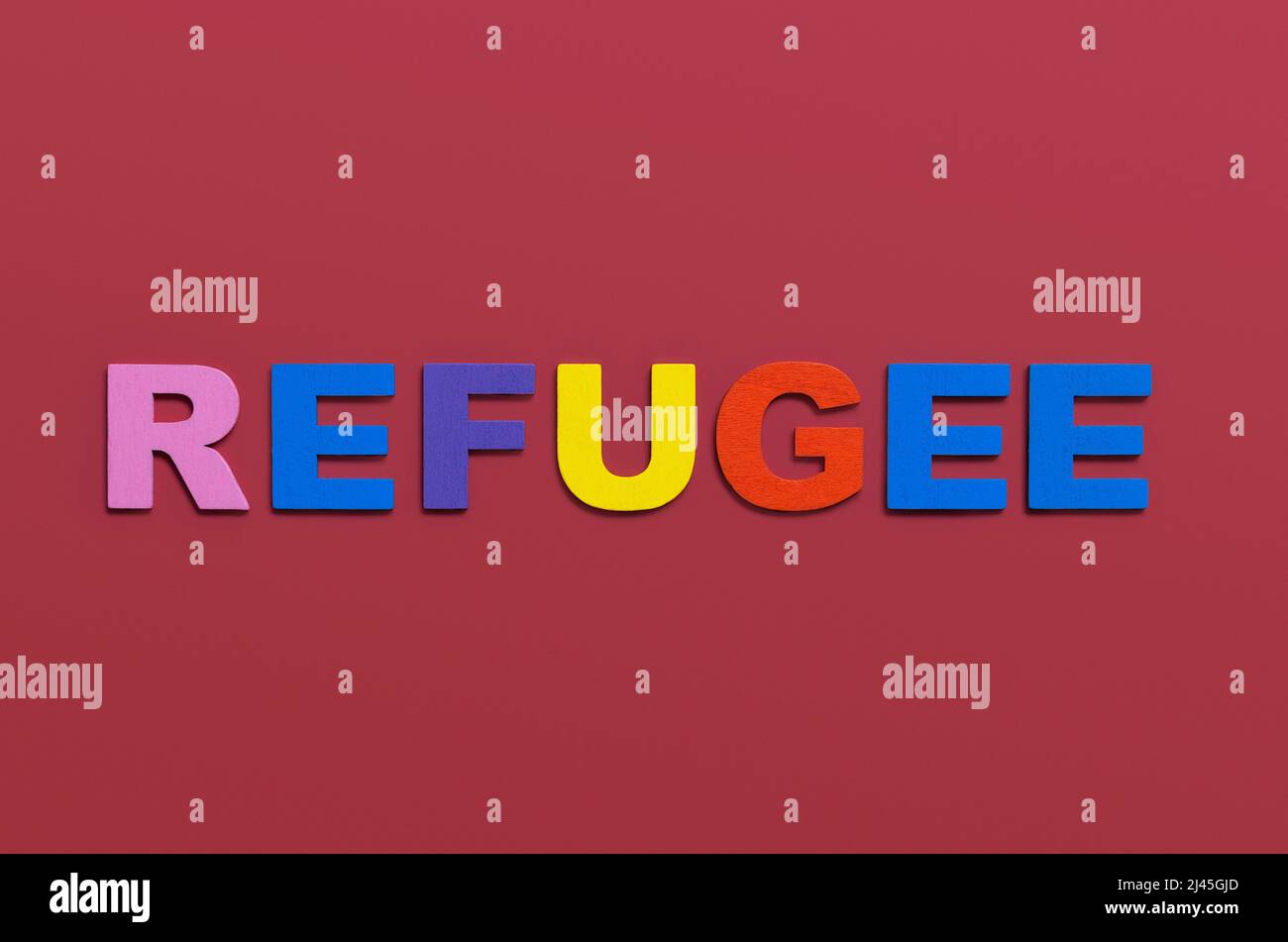 Refugees, word written in colorful wooden alphabet letters on red ...