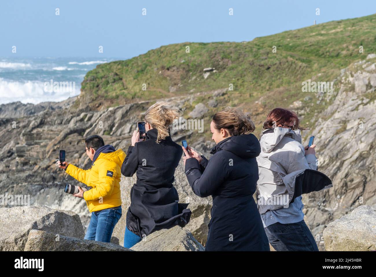 A group of friends using their mobile phones to record the storm force ...