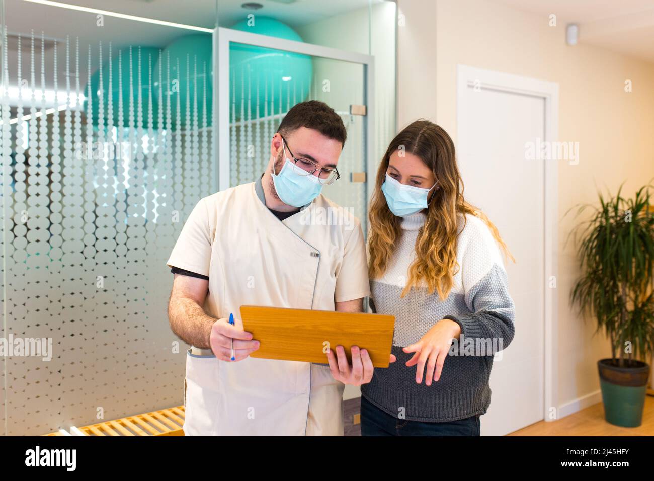 Nurse helping and explaining something to his patient who is being ...