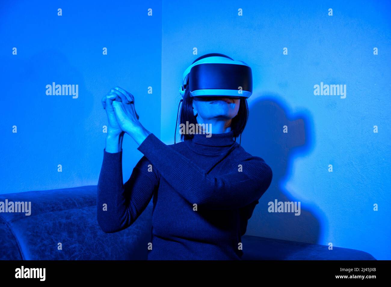 Beautiful woman using vr headset keep hands together, shaking, greeting ...