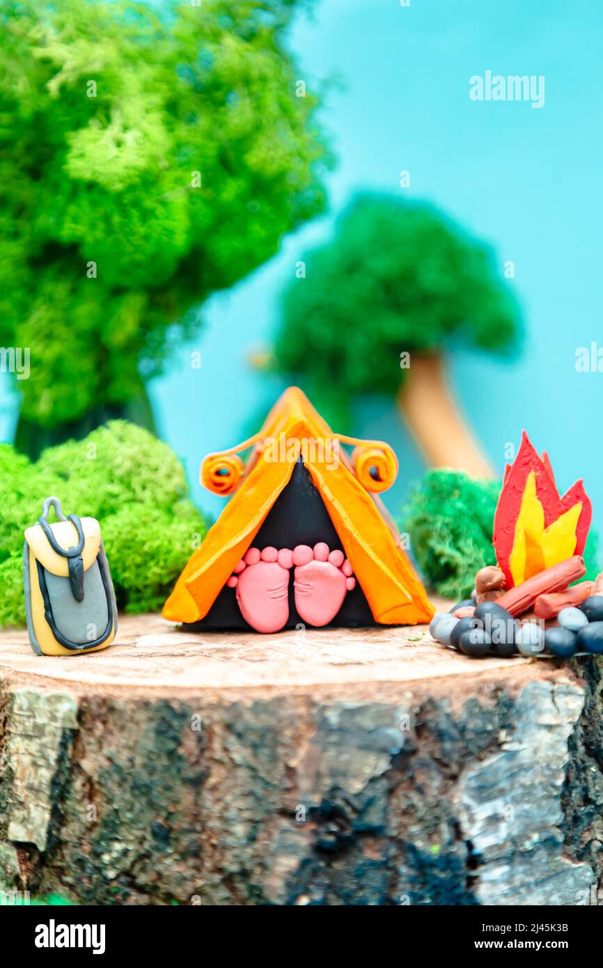 Tourist camp. Plasticine landscape with a tent, a campfire and a ...
