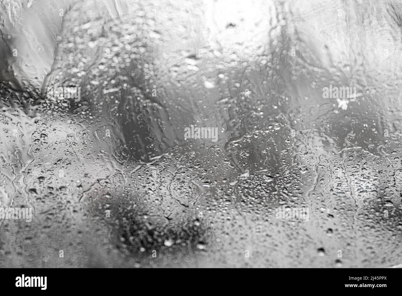 Close the misted glass with water drops flowing down. Dripping ...