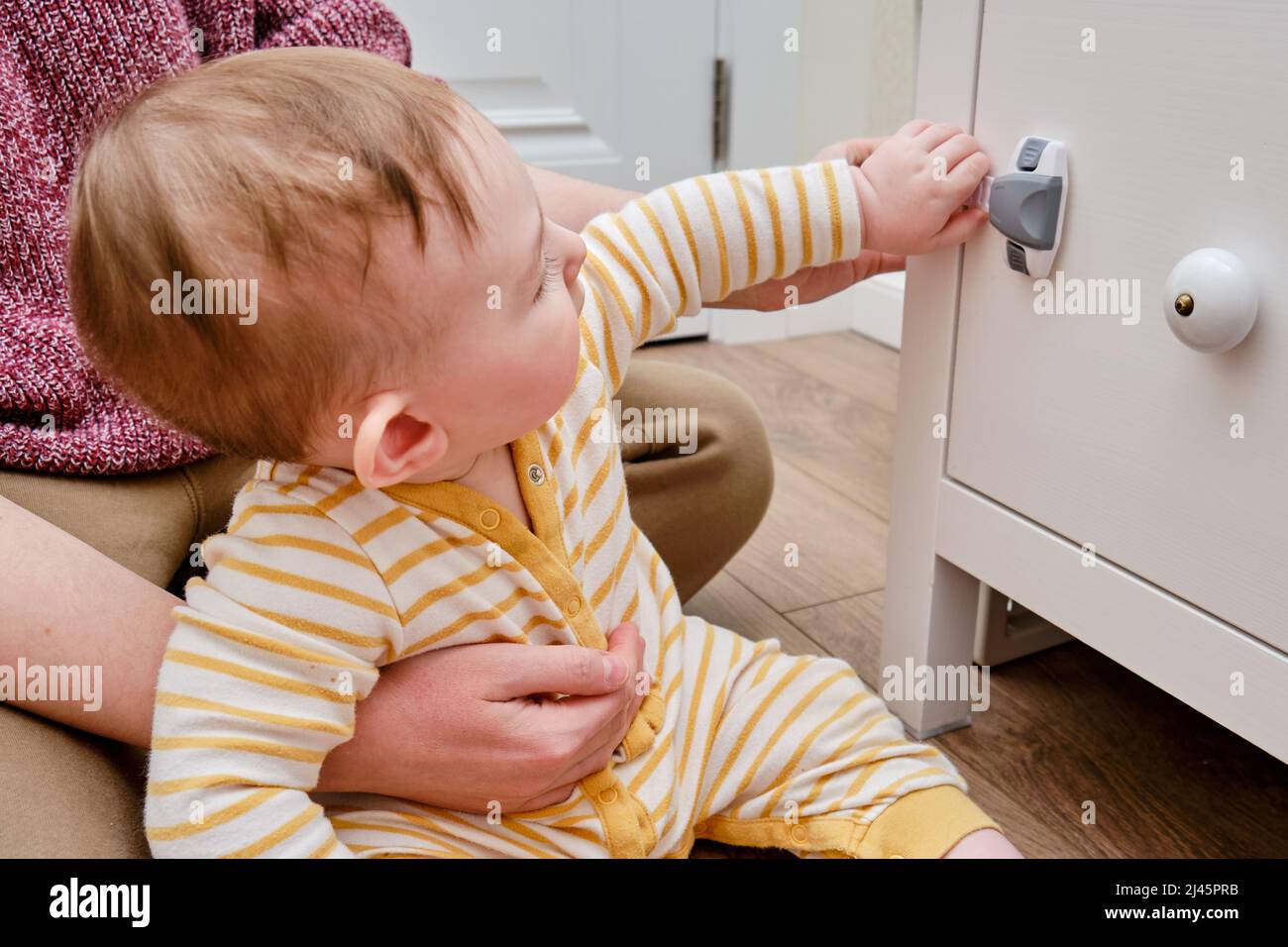 Danger for the baby to pinch the hand of the cabinet door or chest of ...