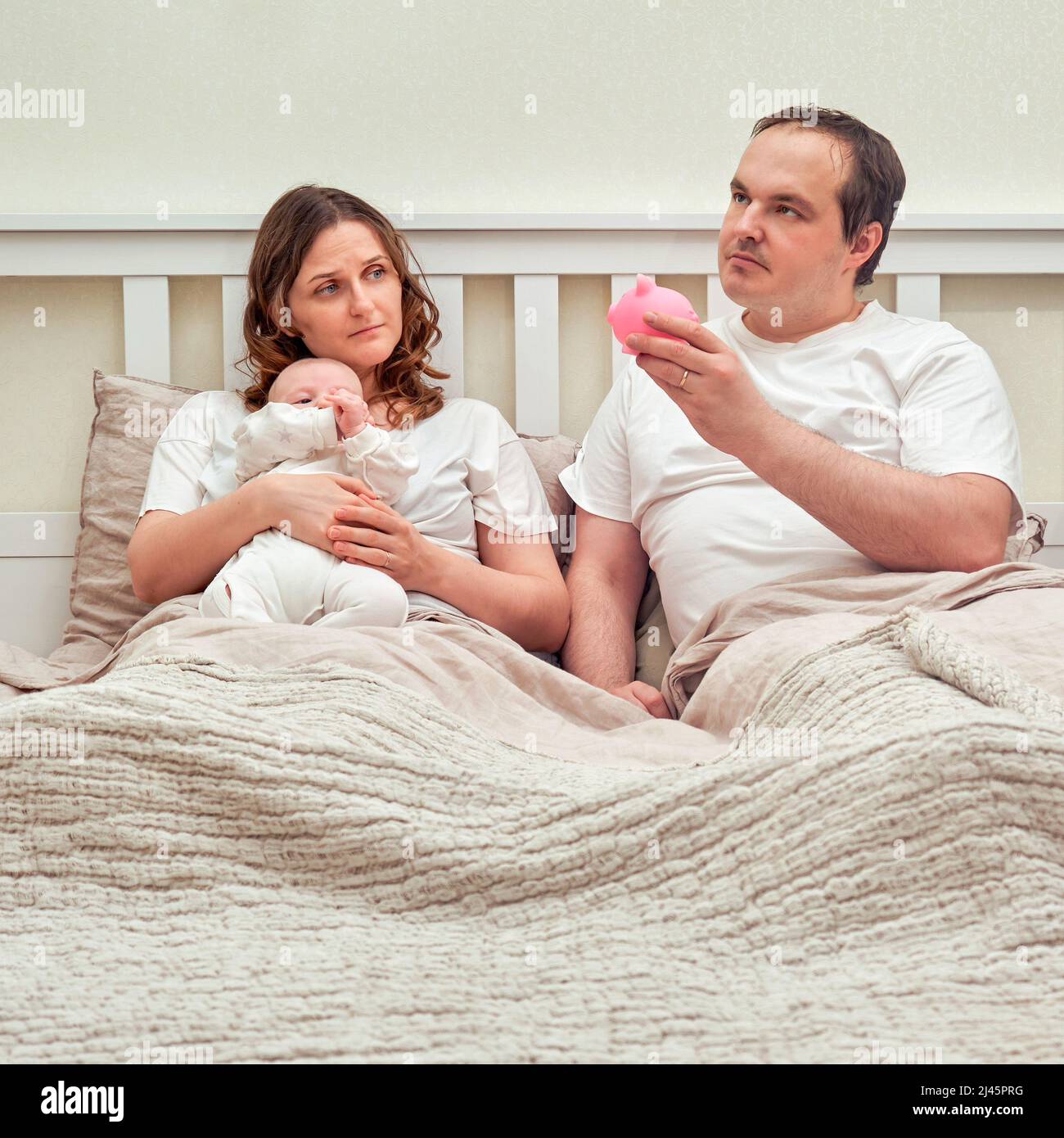 Mother and father with baby boy with money for upbringing, financial problems of parents with ...