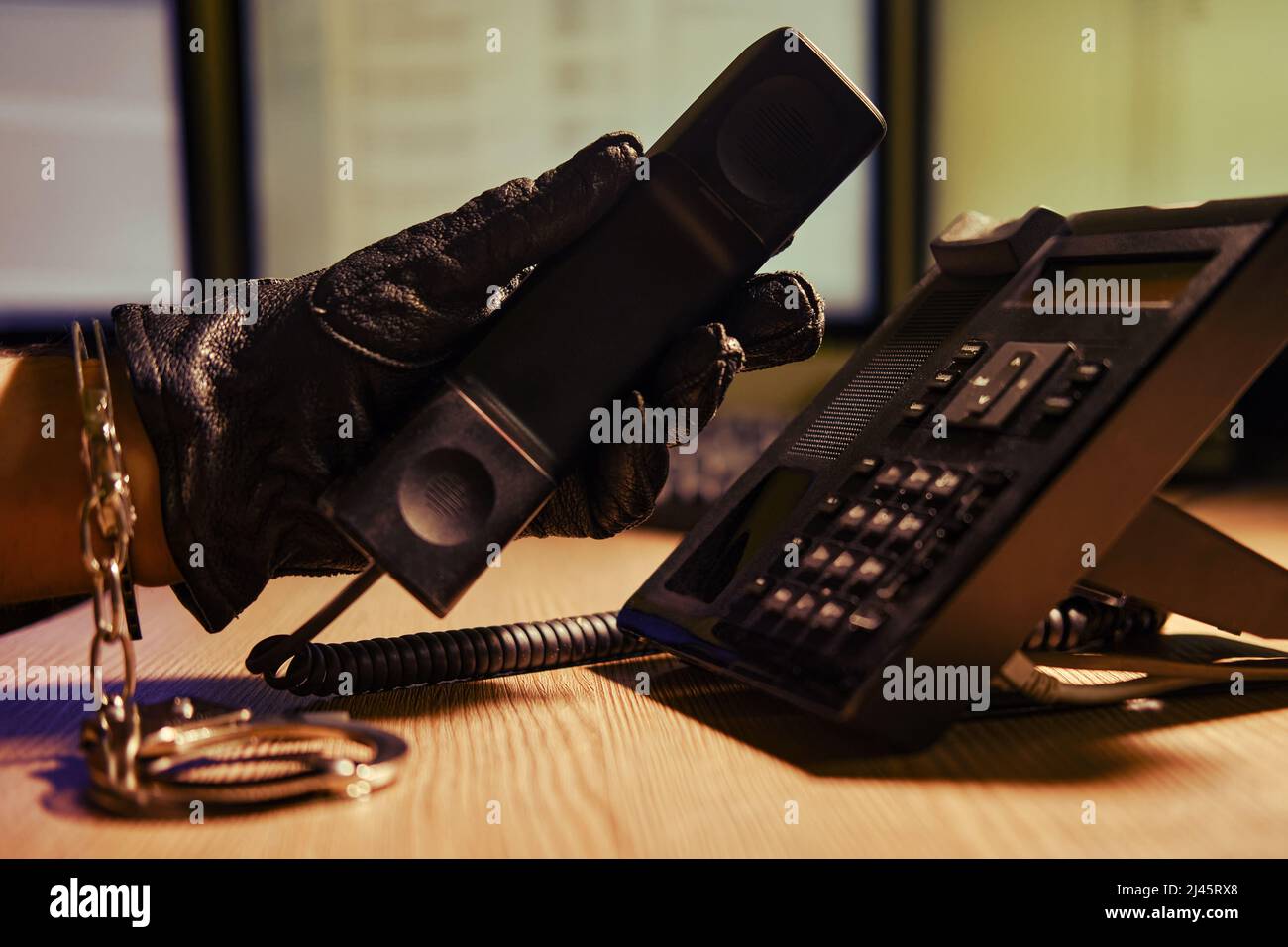 A man in black gloves at the phone in handcuffs on his hands, close-up ...
