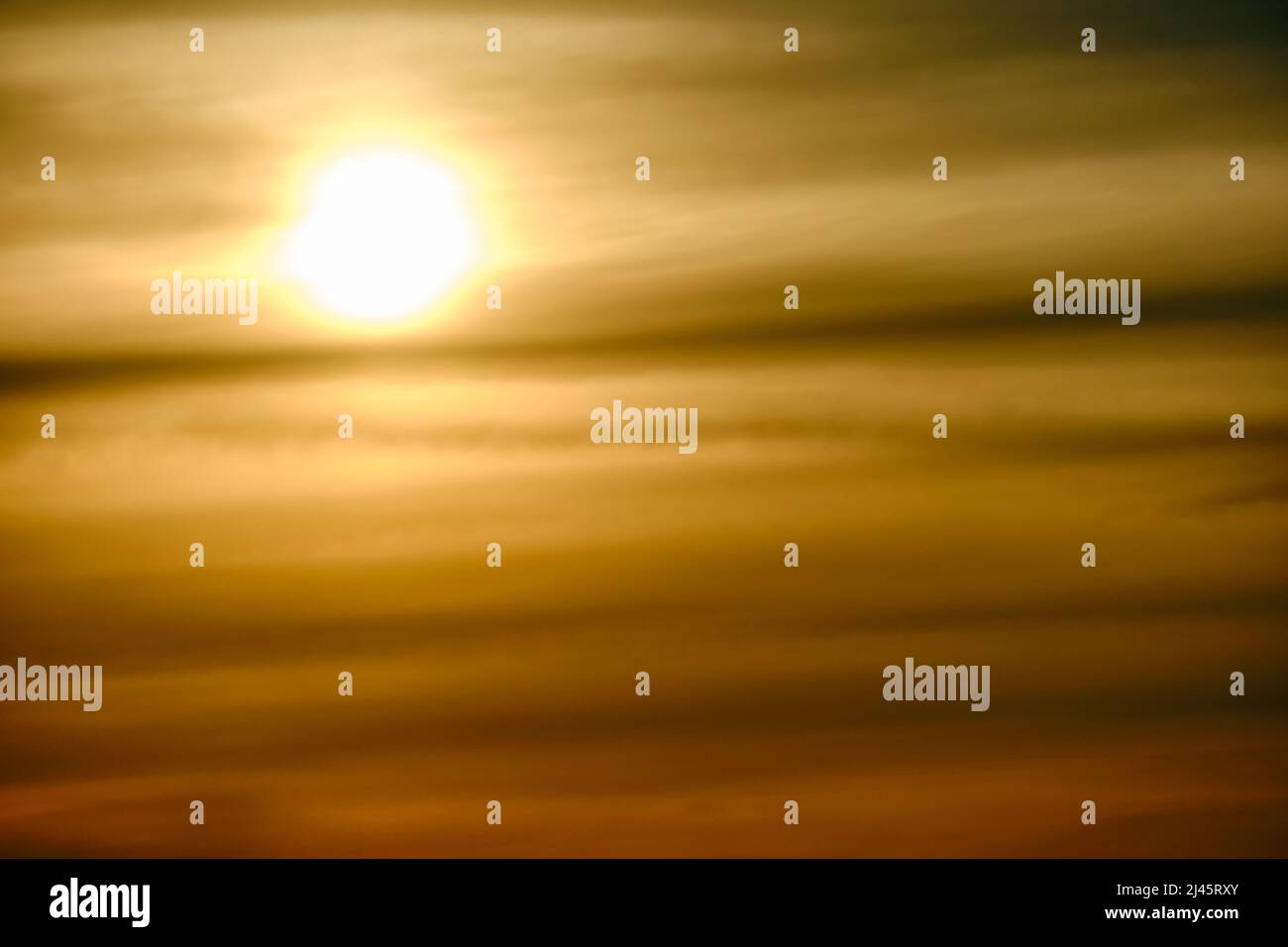 Evening sun through overcast clouds on a hot misty sky. Sunset in a ...