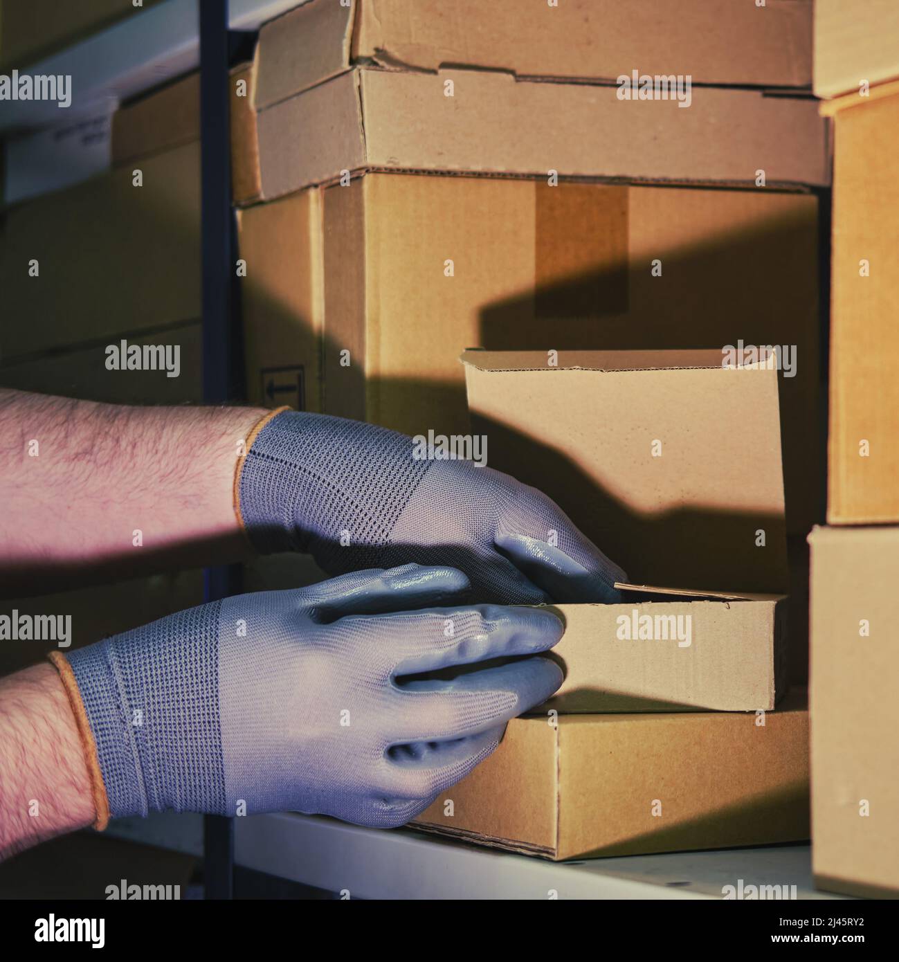 A man in gloves steals goods from a box in a warehouse. Problems with ...