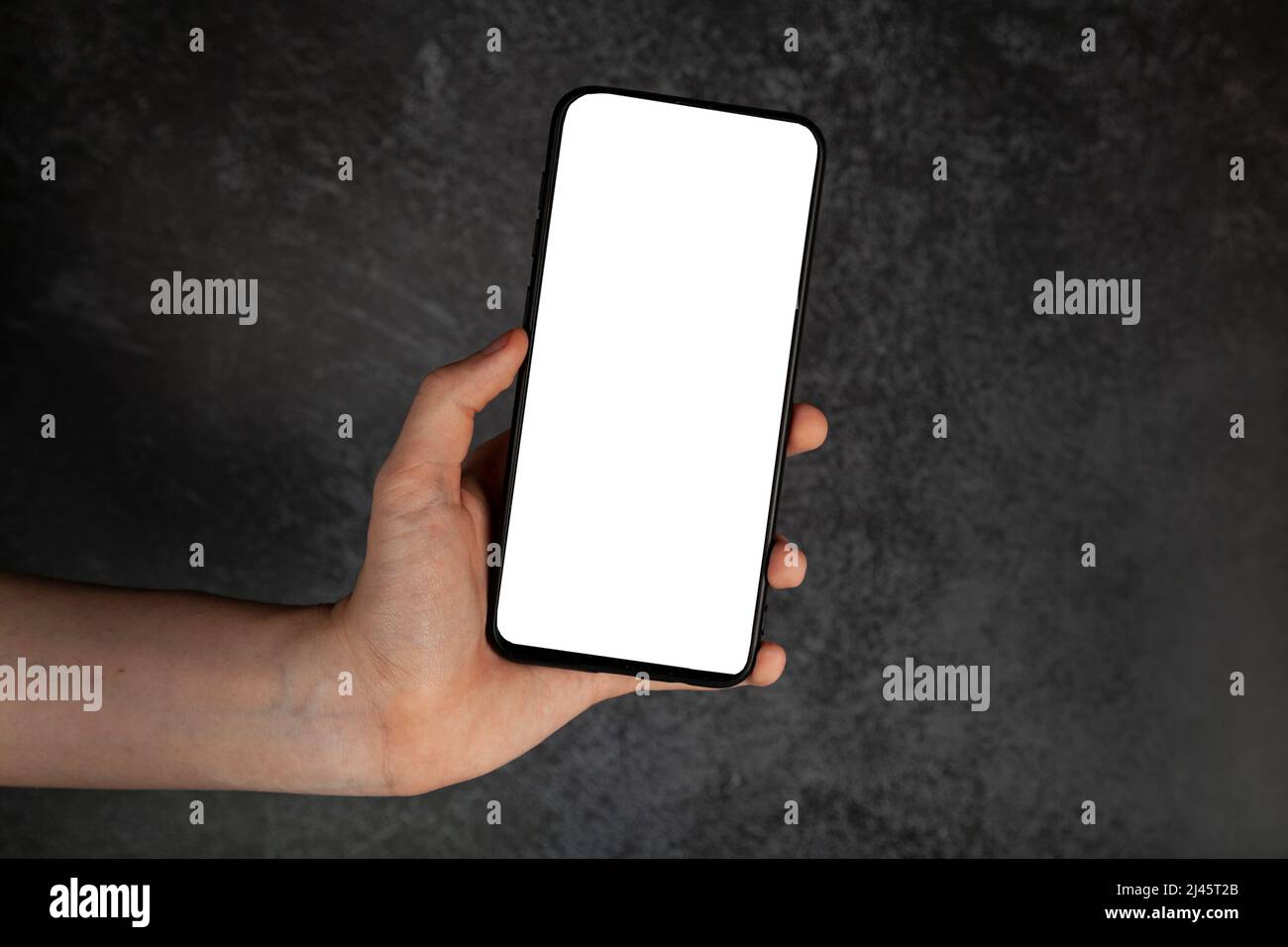 Smartphone in hand. White screen, copy space, dark background Stock ...