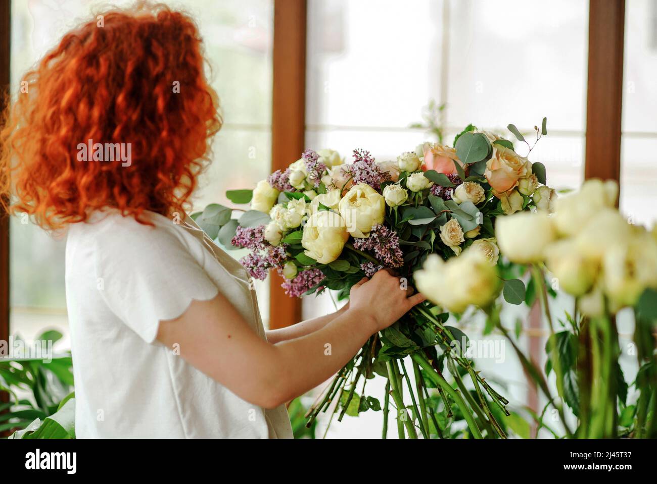 Florist woman creates flower arrangement in a round box. Beautiful ...