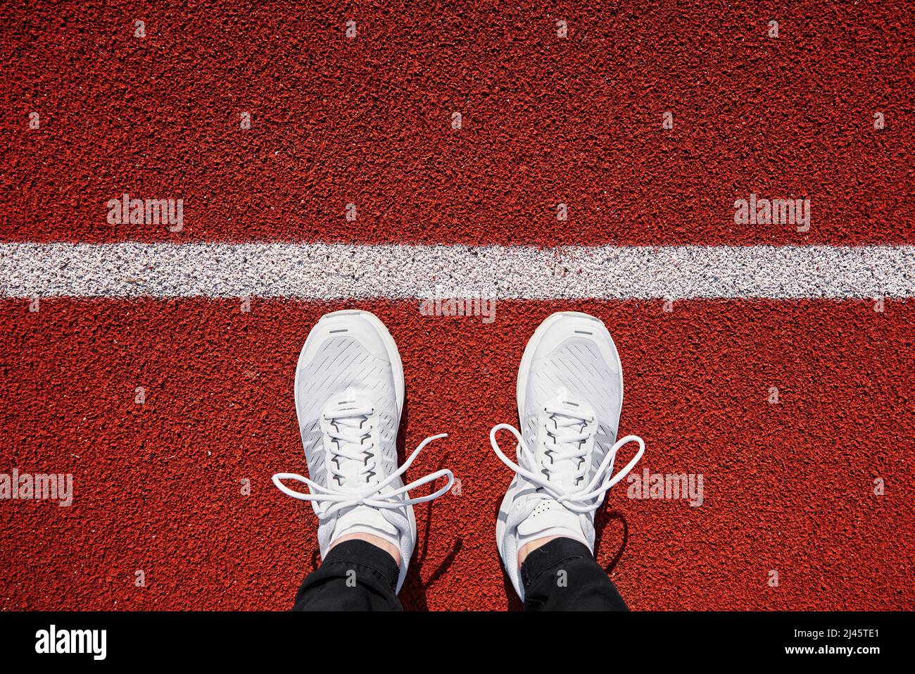 Top view of white male running sneakers near start line at stadium ...