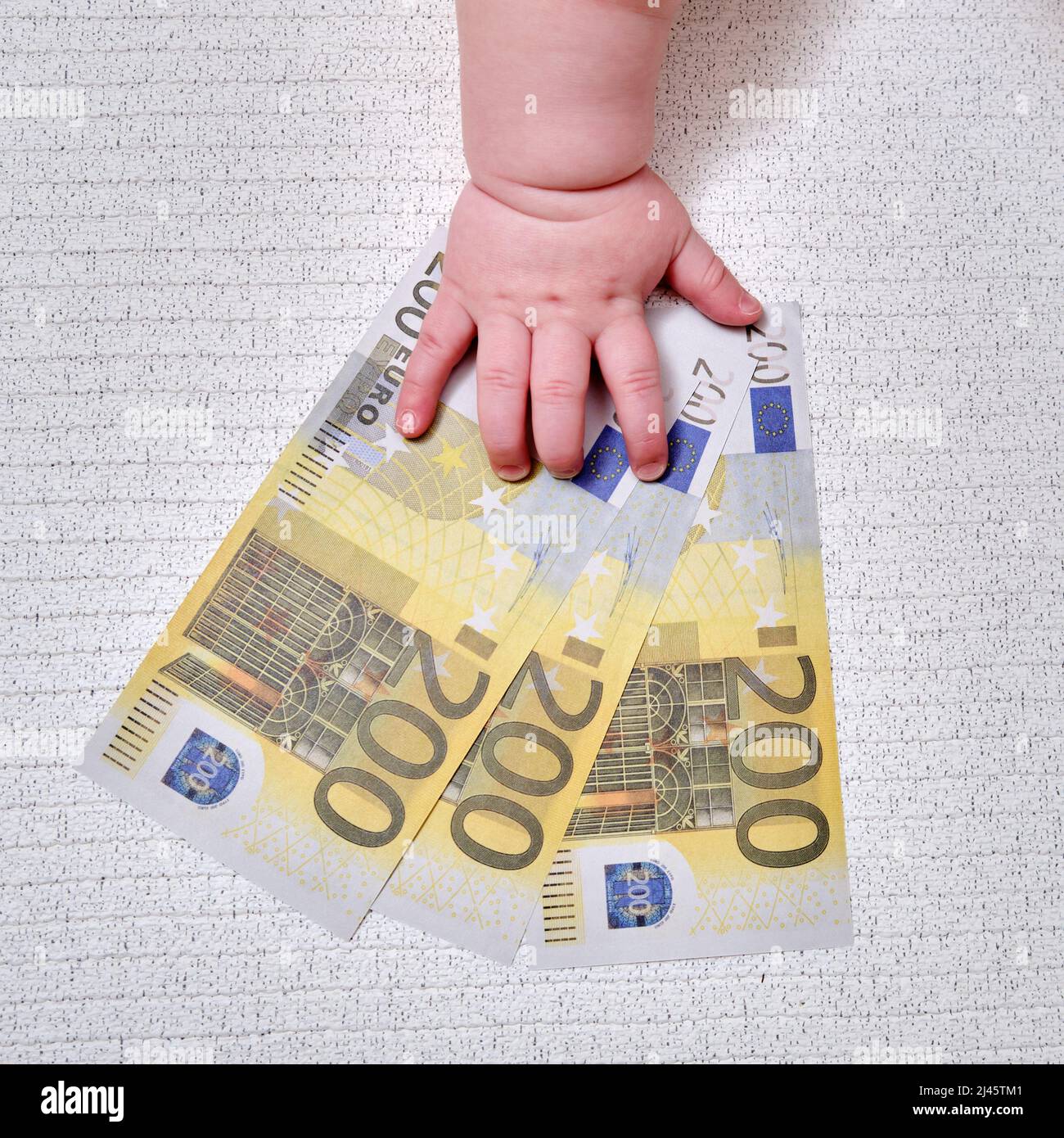 Baby hand and euro money, close-up. Children fingers and an object on a ...
