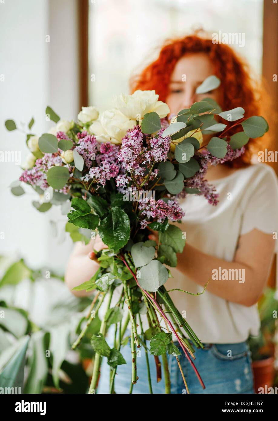 Florist woman creates flower arrangement in a round box. Beautiful ...