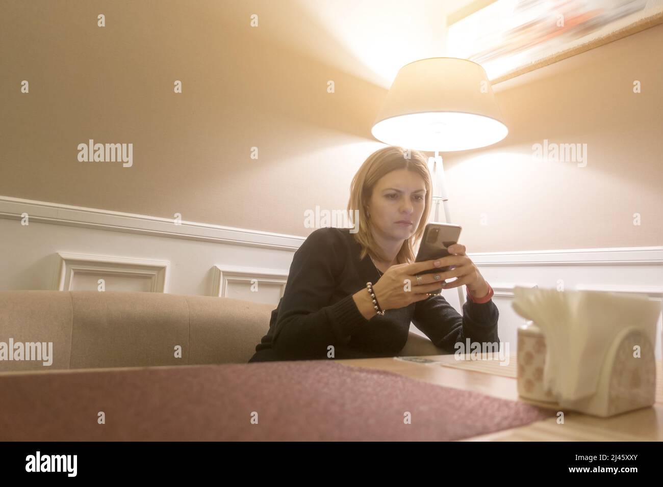 Girl writes a message at a table in a cafe Stock Photo - Alamy