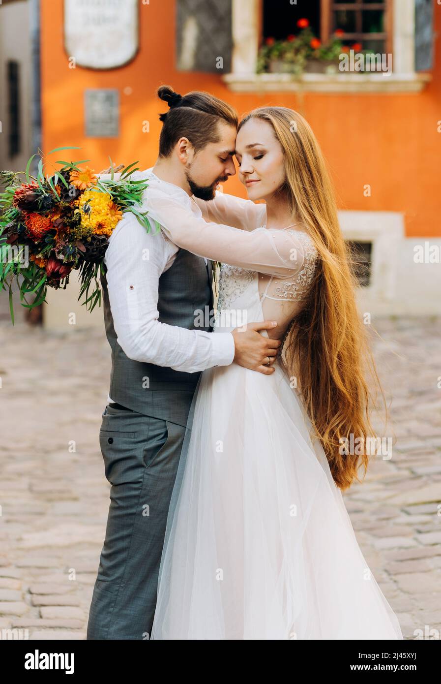 Lovely young couple hugging each other in the yard on a background of ...
