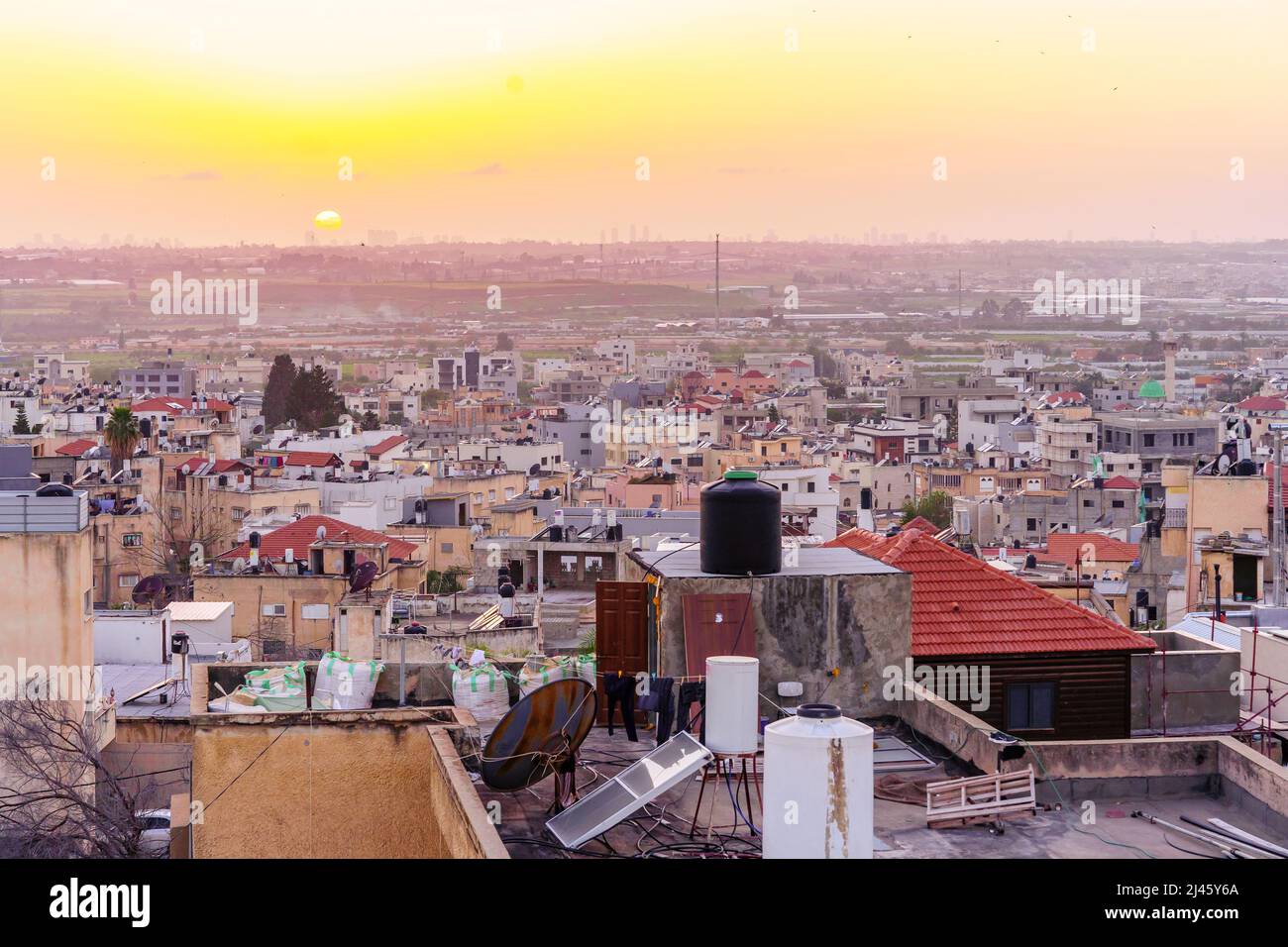 Sunset rooftop view of the center of Tayibe, a Muslim Arab town in ...