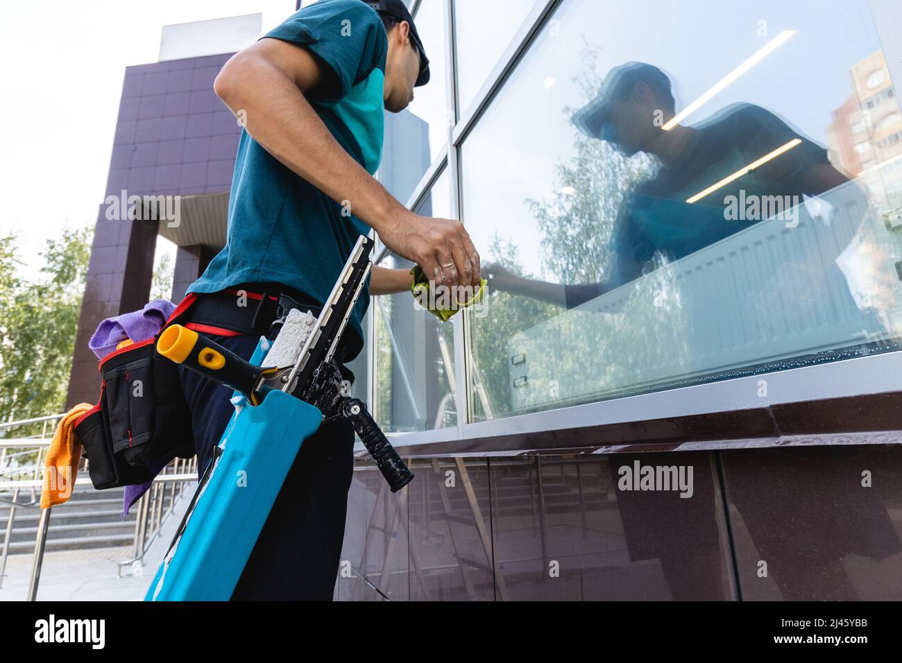 Male professional cleaning service worker in overalls cleans the ...