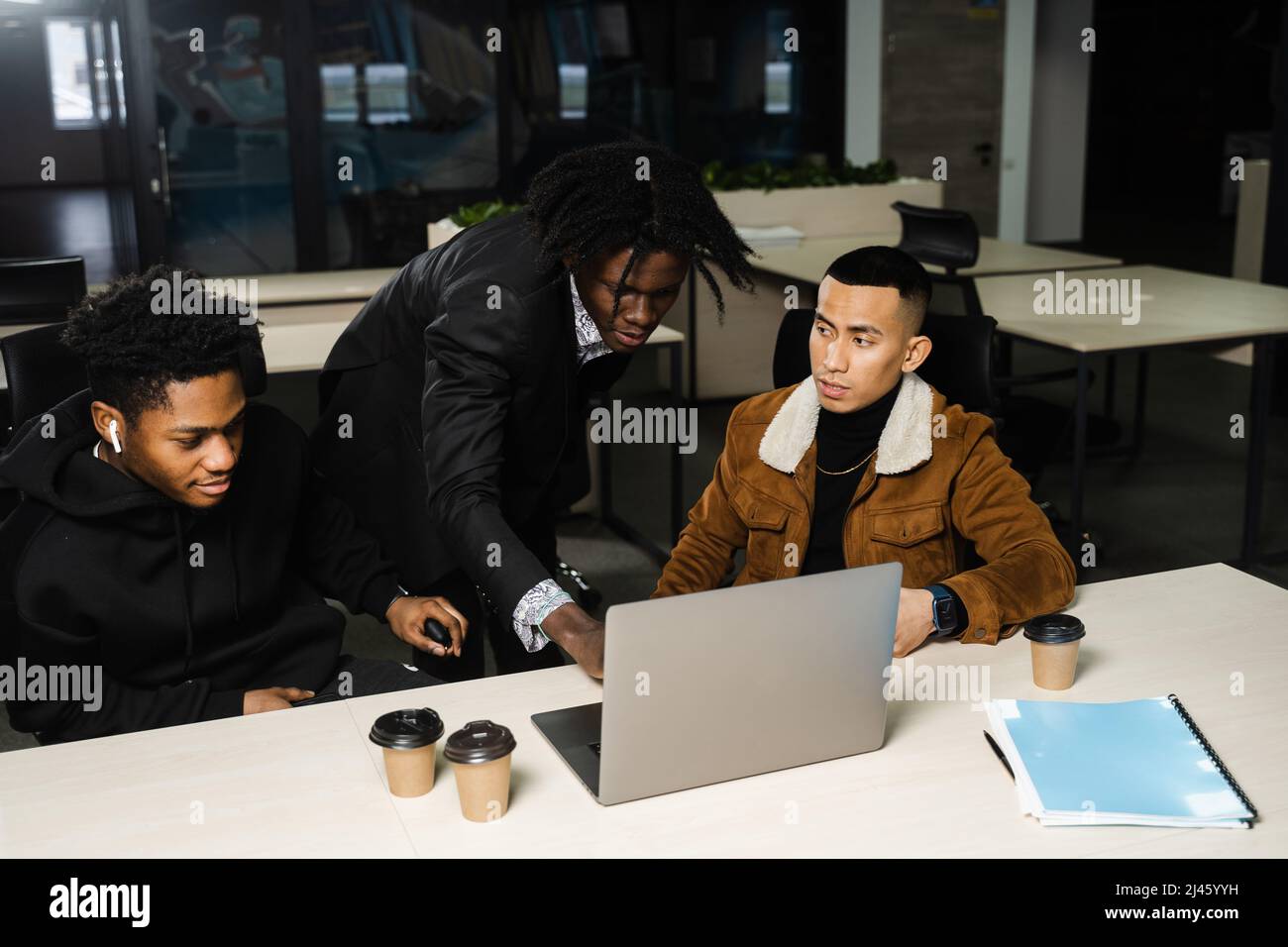 Teamwork of 2 black african and asian with laptop. Colleagues in ...