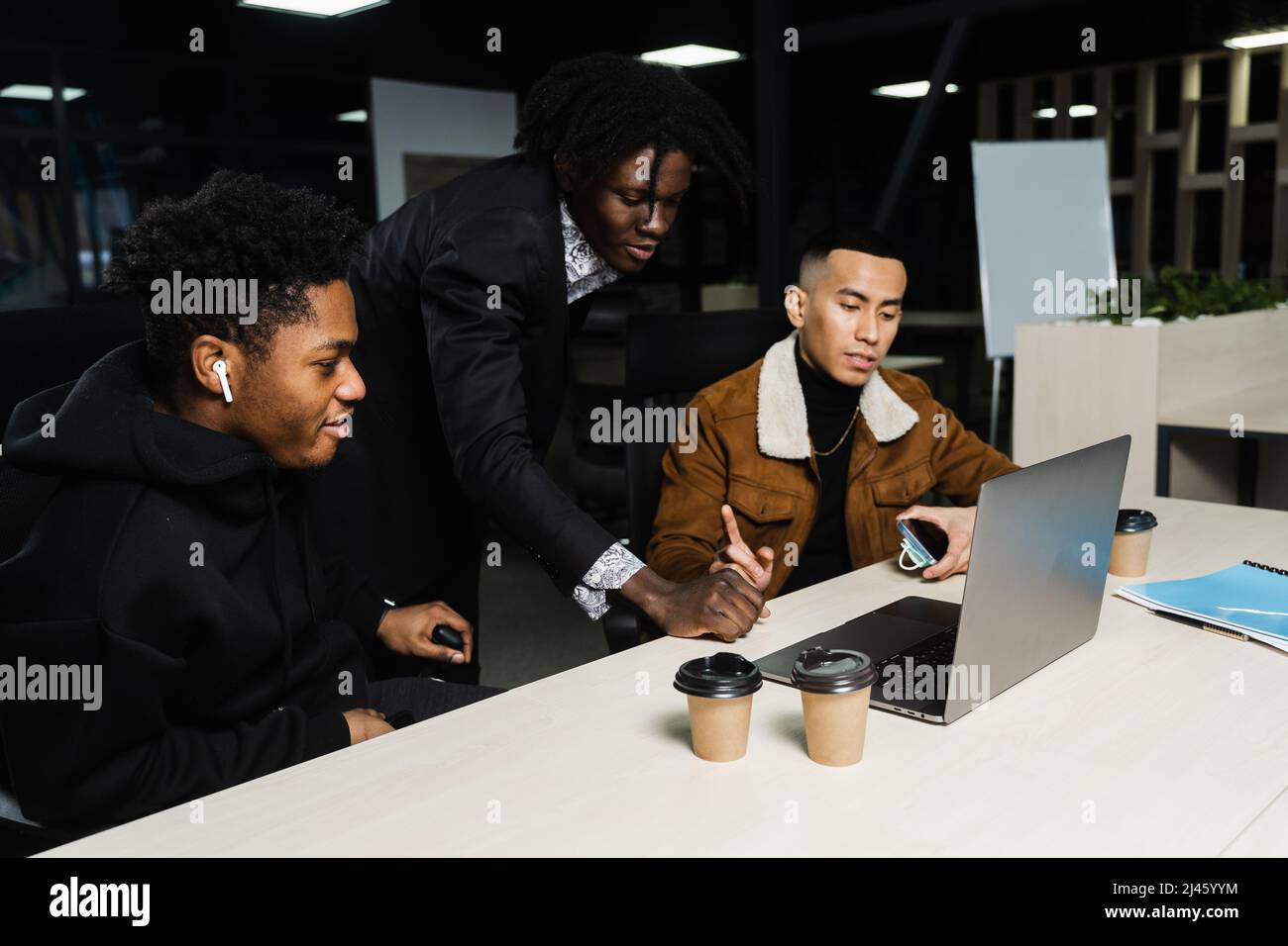 Teamwork of 2 black african and asian with laptop. Colleagues in ...