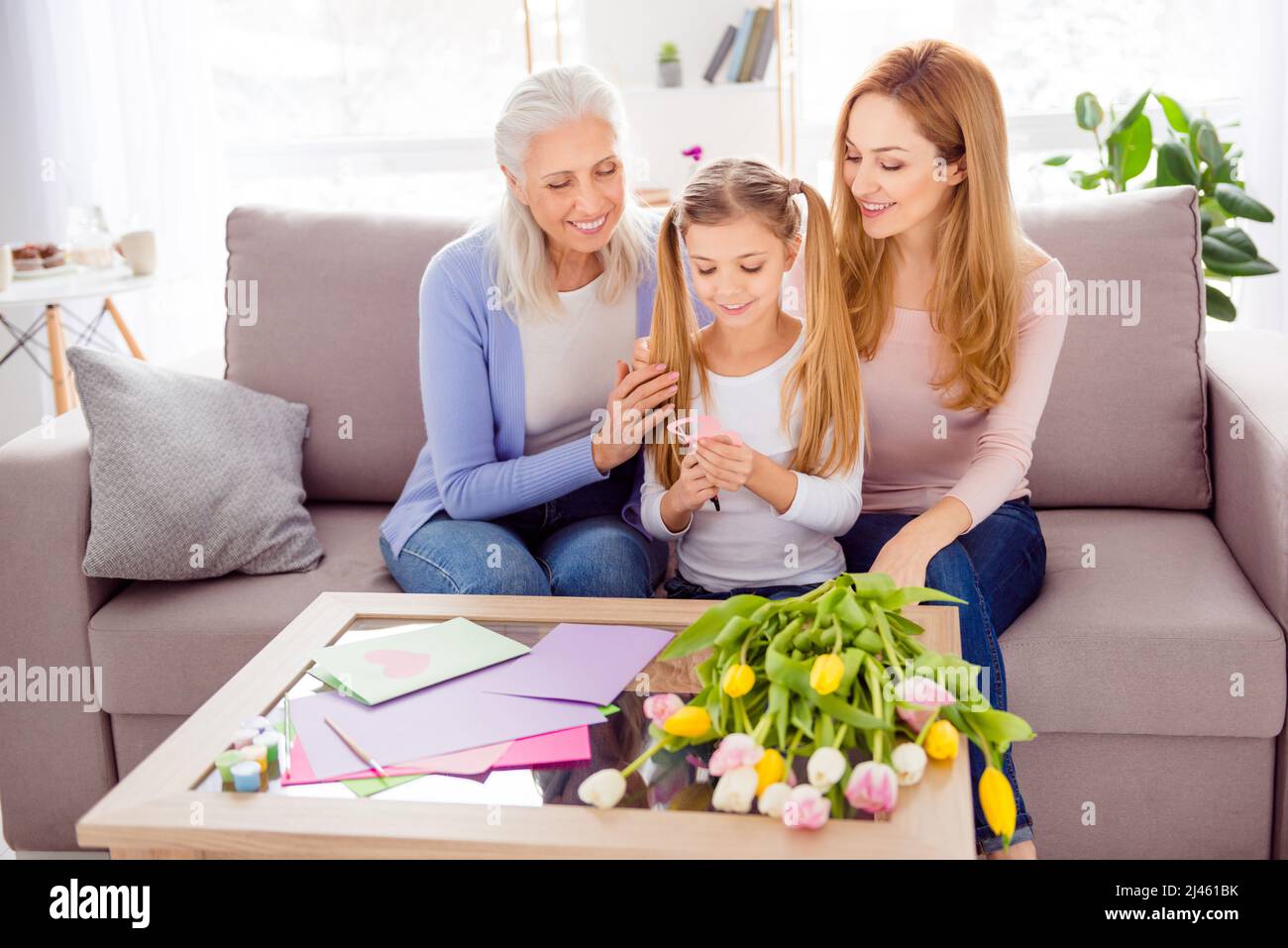 Portrait of three idyllic people sitting sofa help make gift card house ...