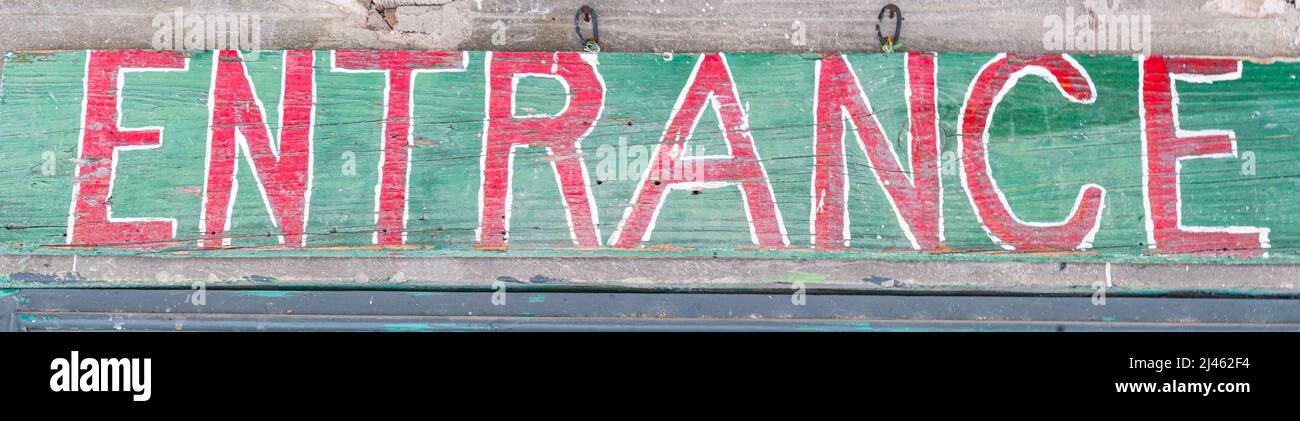Weathered old wooden hand painted entrance sign Stock Photo - Alamy