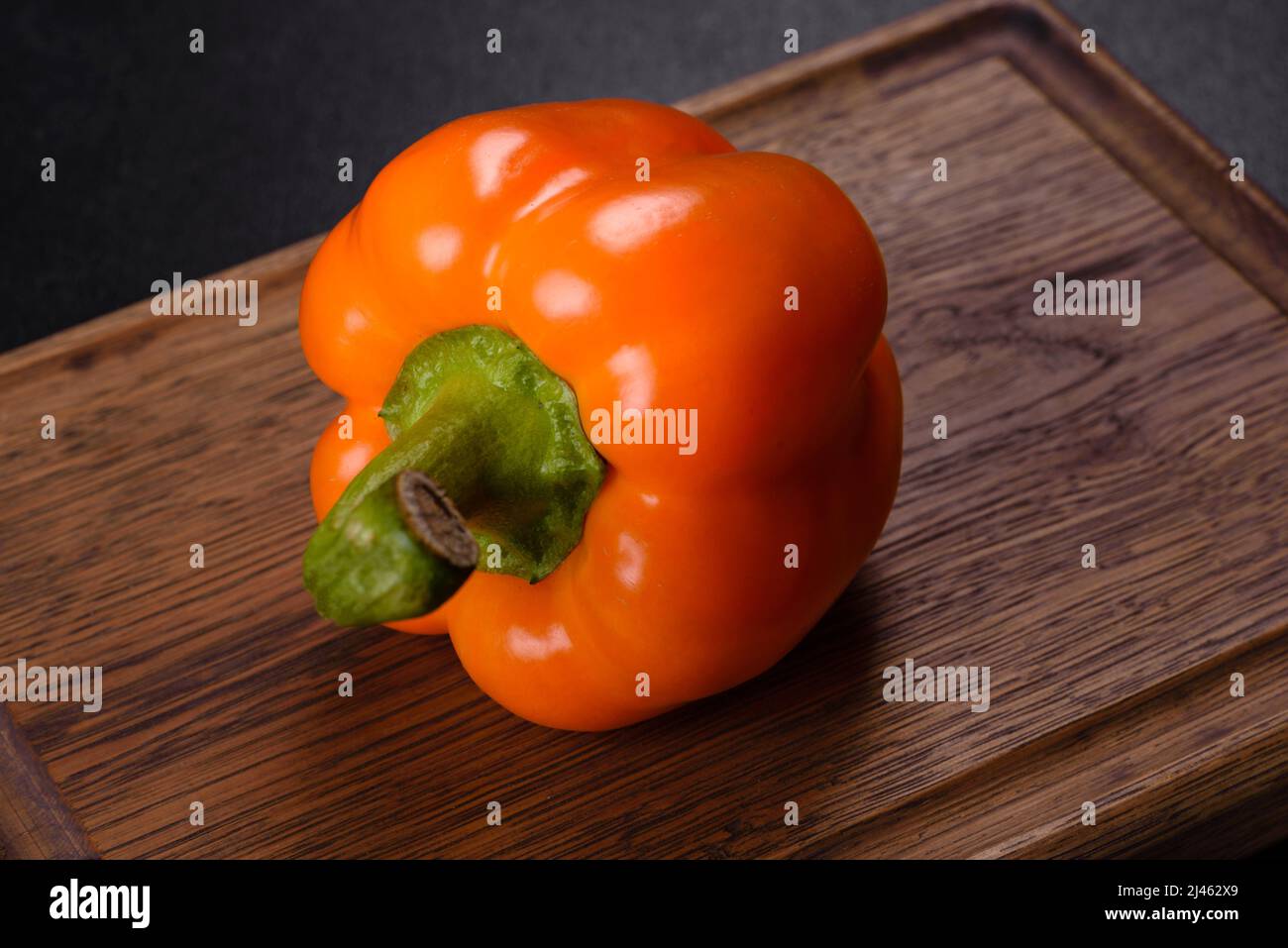 Fresh beautiful bell pepper orange on a dark concrete background ...