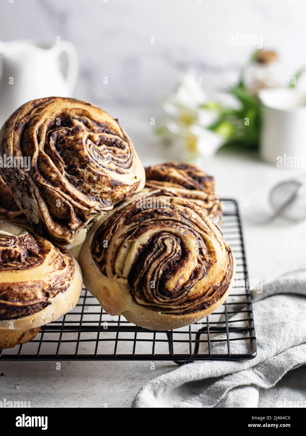 Close-up Cinnamon roll buns or swirl brioche on pastry rack with linen ...
