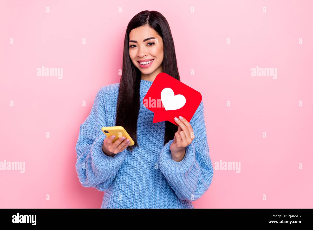 Portrait of beautiful trendy girl using device holding heart card smm ...