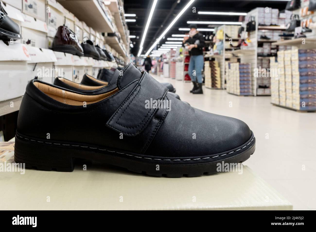 Shoes standing in a row on a shelf in a shoe store. New shoes, black ...