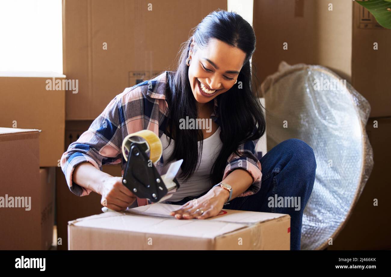 After moving house the hard part comes unpacking. Shot of a young woman ...