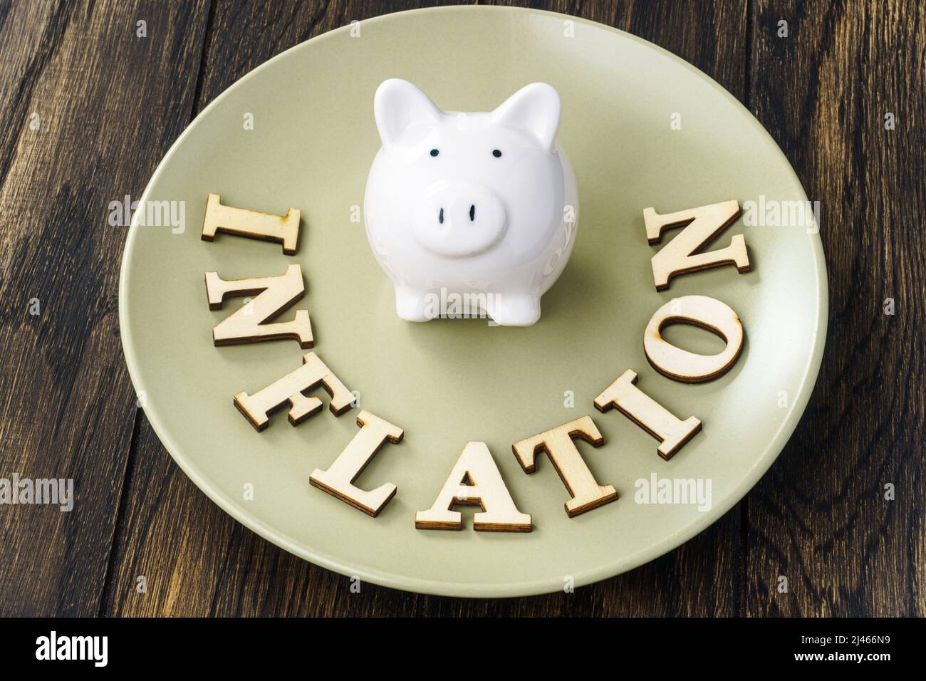 Inflation spelled in letters and piggy bank on plate. Food inflation ...