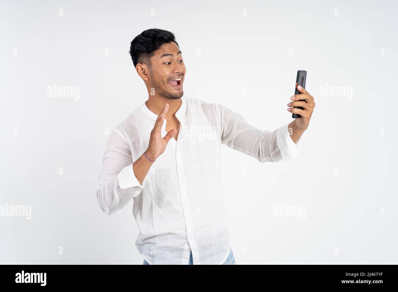 excited young man making video call waving one hand Stock Photo - Alamy