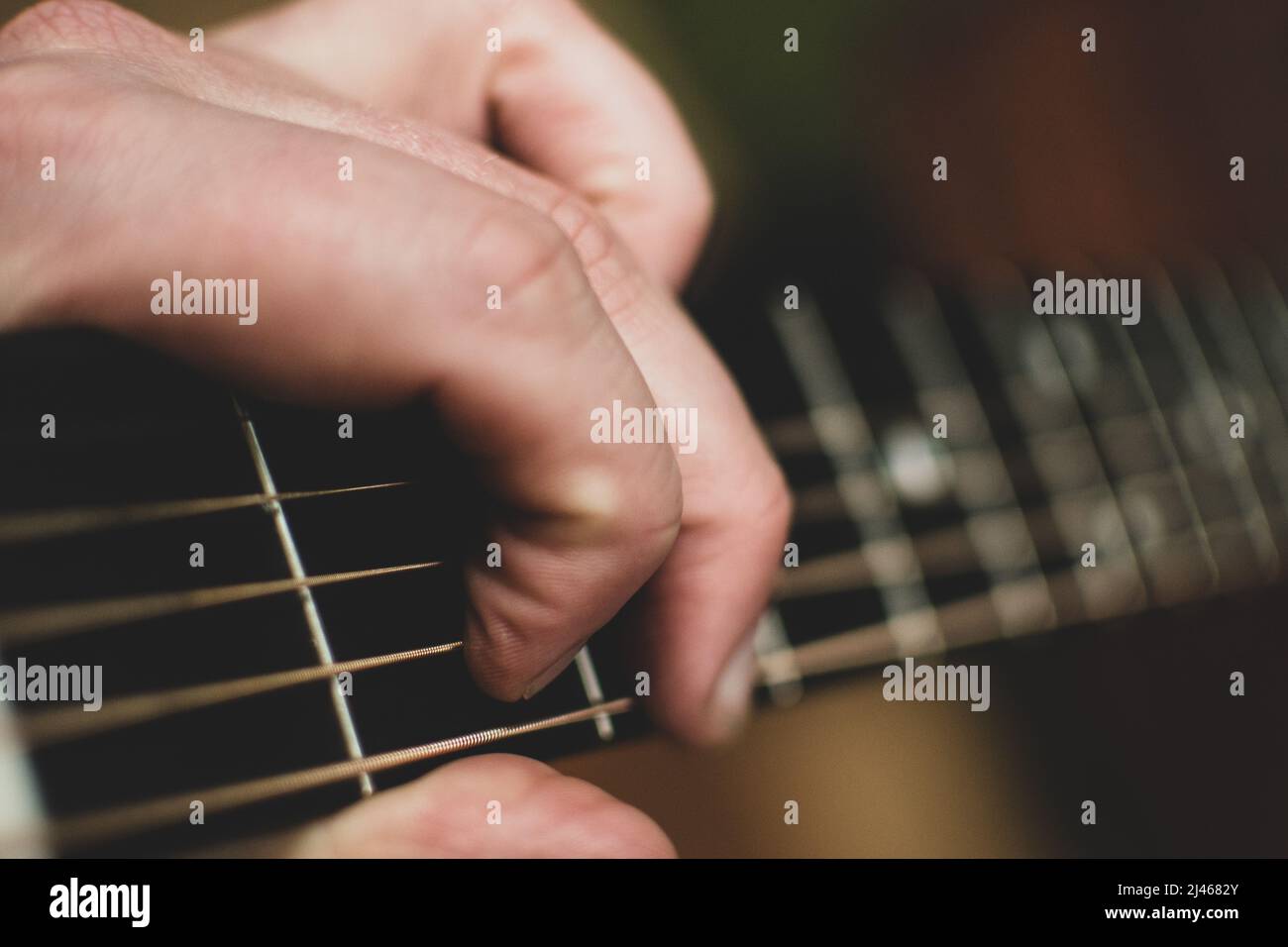 A close up inverted view of a hand forming a chord whilst playing music ...